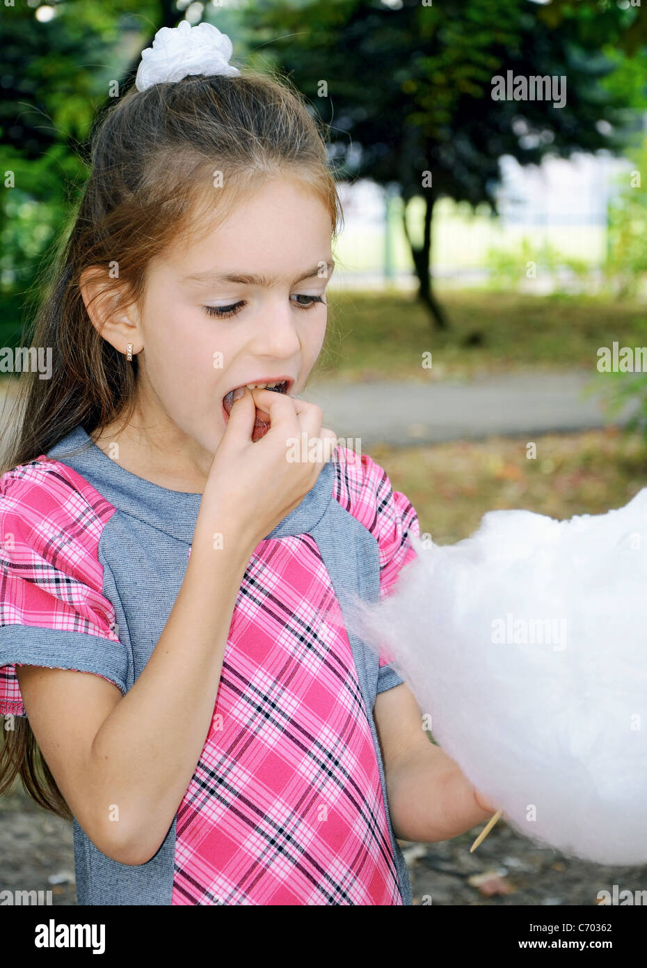 a girl eating sweet cotton wool Stock Photo - Alamy