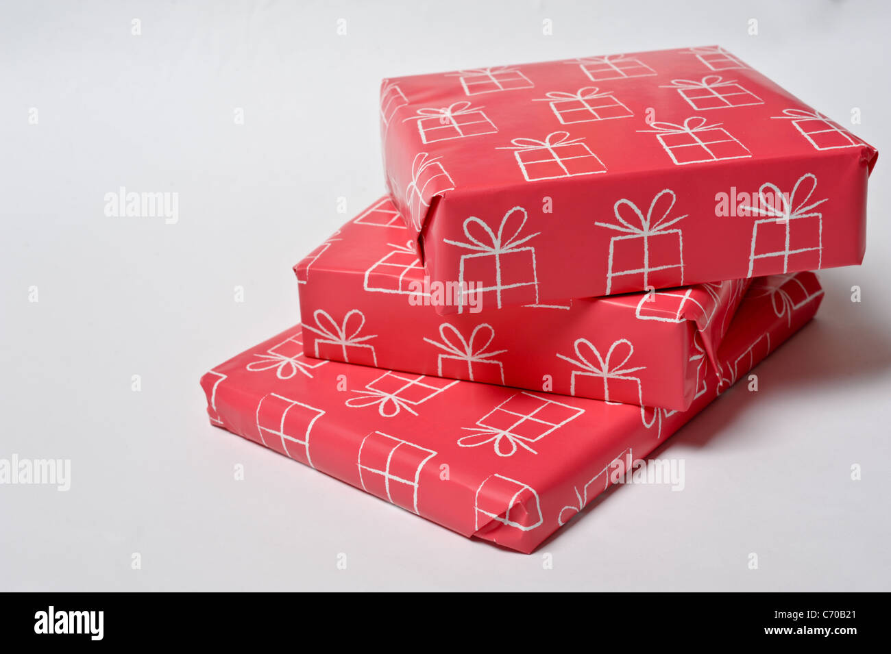 Three birthday presents wrapped up in pink paper and piled up on each ...