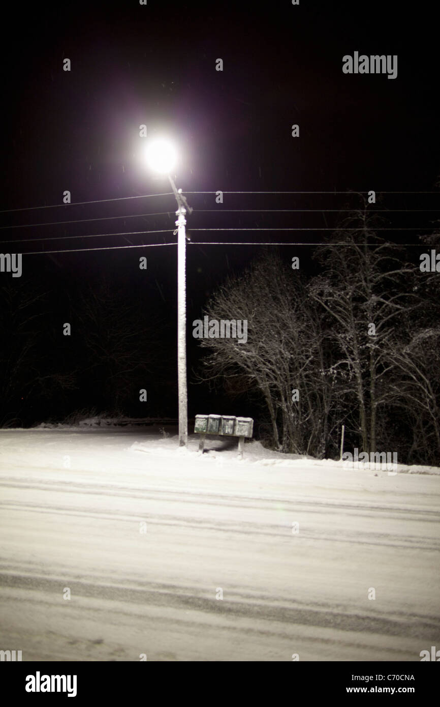 Streetlight over snowy road at night Stock Photo - Alamy