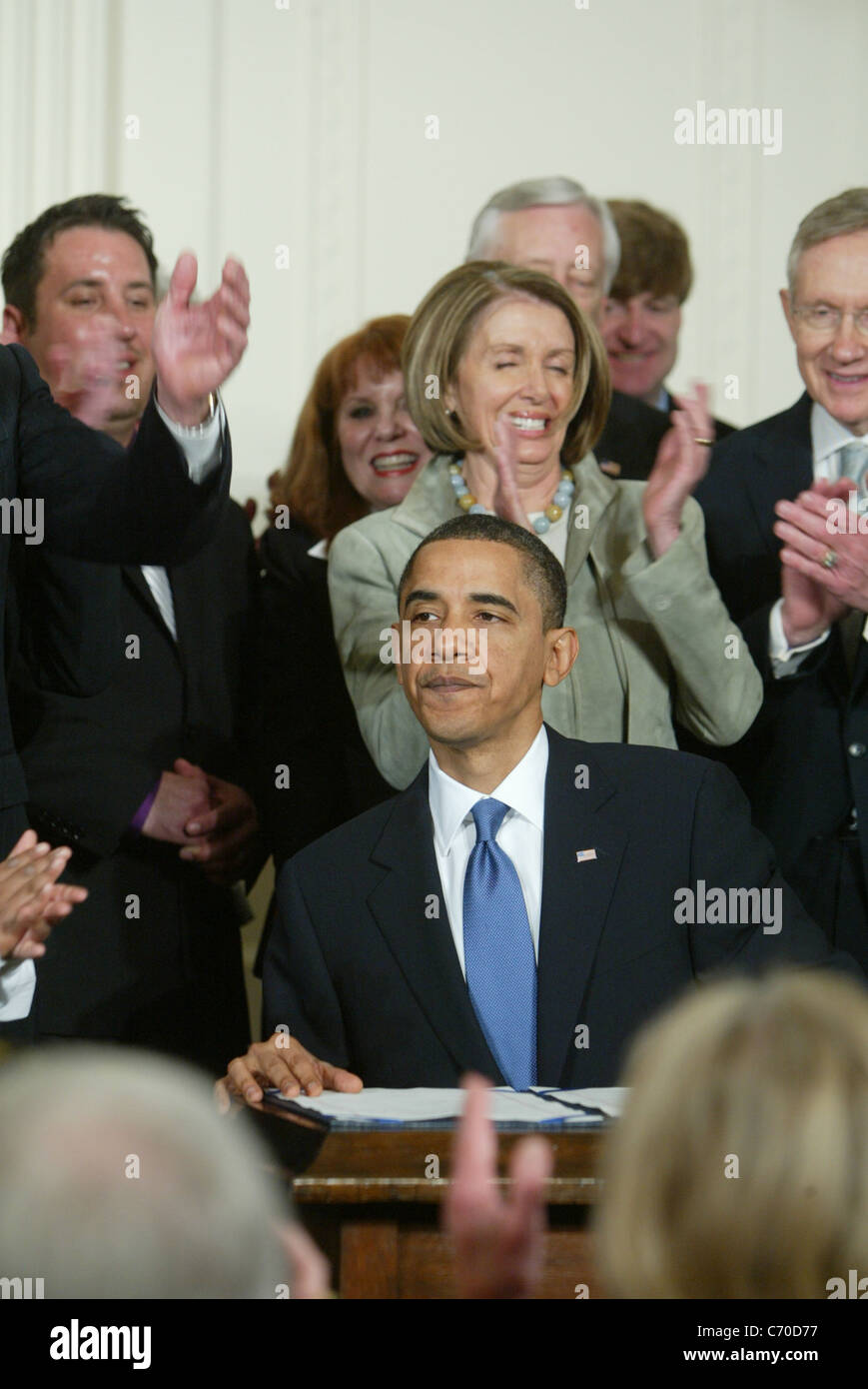 President Obama signs the bill surrounded by congressional supporters ...