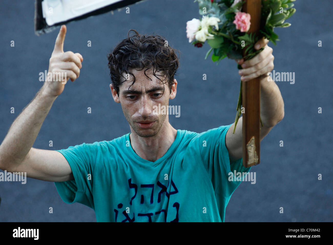 An Israeli demonstrator holds a flower bouquet during Cost of Living ...