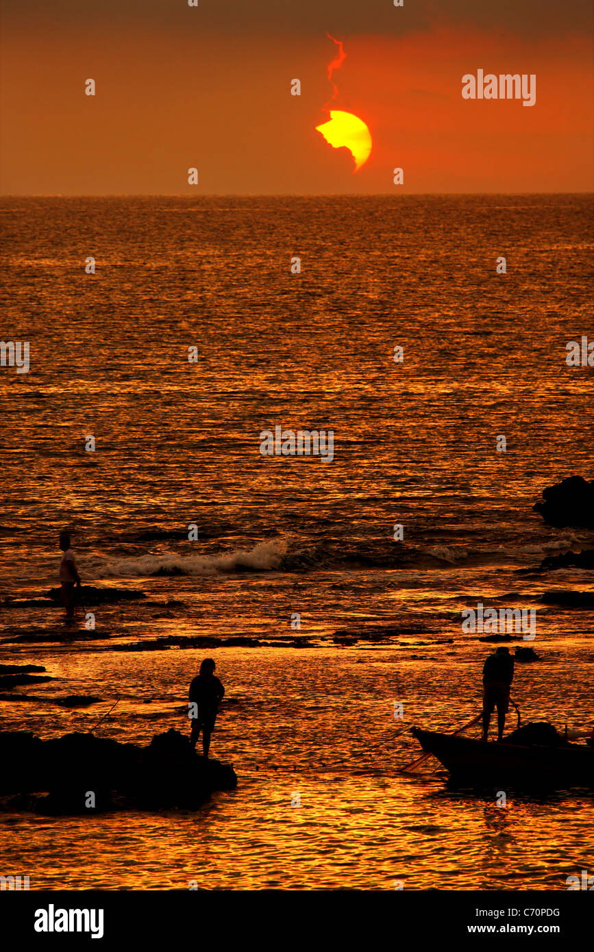 Fishermen fishing in the Ionian sea around sunset, at the beach close ...