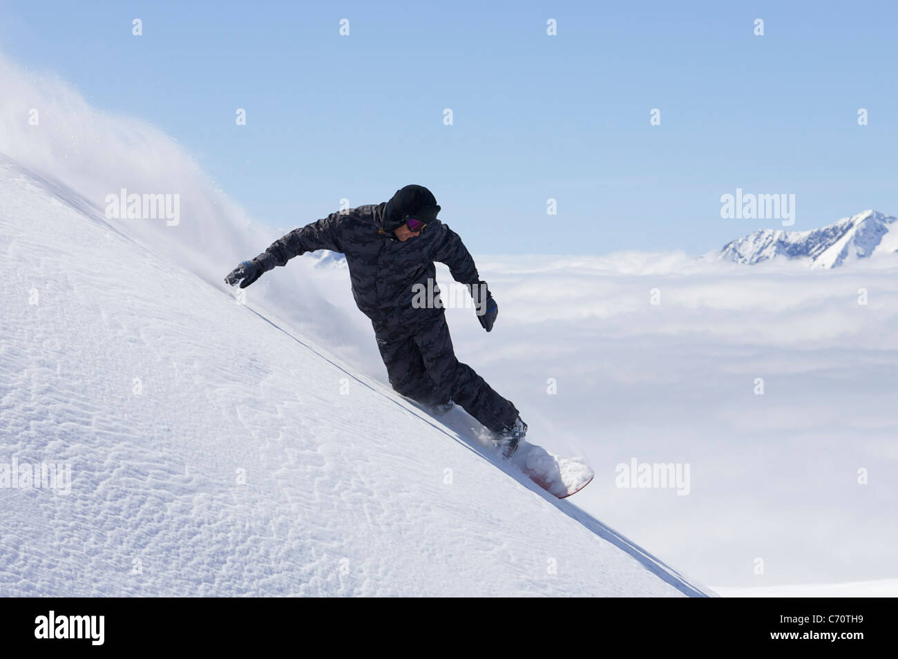 Snowboarder doing tricks on slope Stock Photo - Alamy