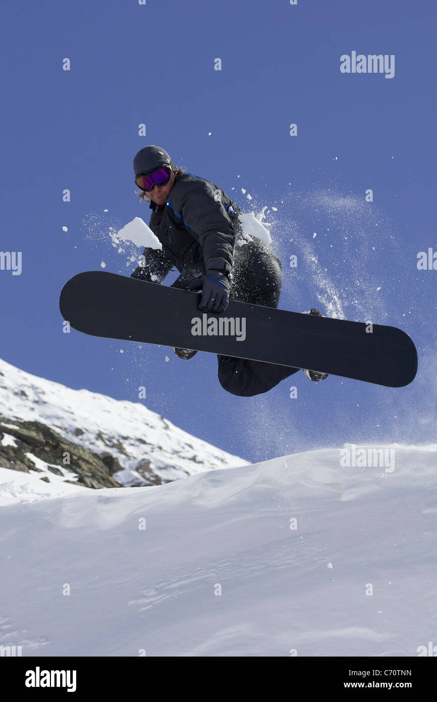 Snowboarder doing tricks on slope Stock Photo - Alamy