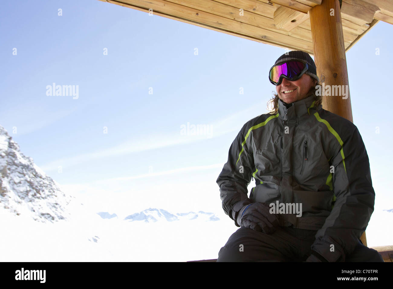 Man relaxing on ski lodge balcony Stock Photo - Alamy