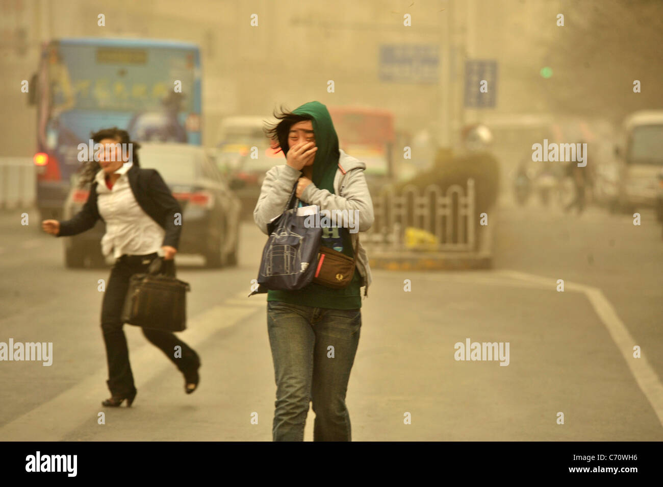 A woman covers her mouth during a sandstorm in Lanzhou in northwest ...