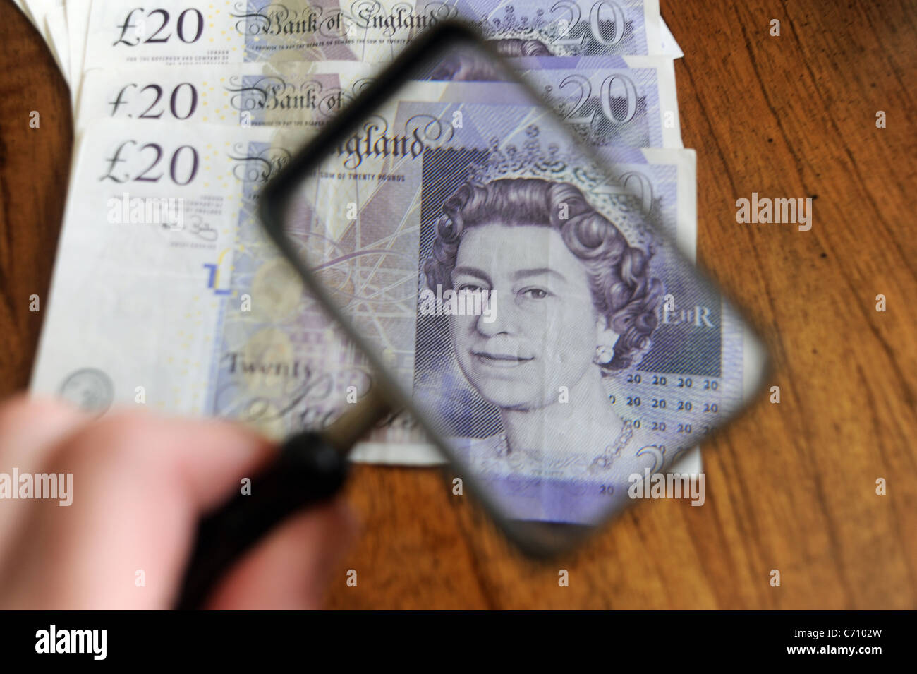 Bank of England £20 sterling notes under a magnifying glass Stock Photo ...