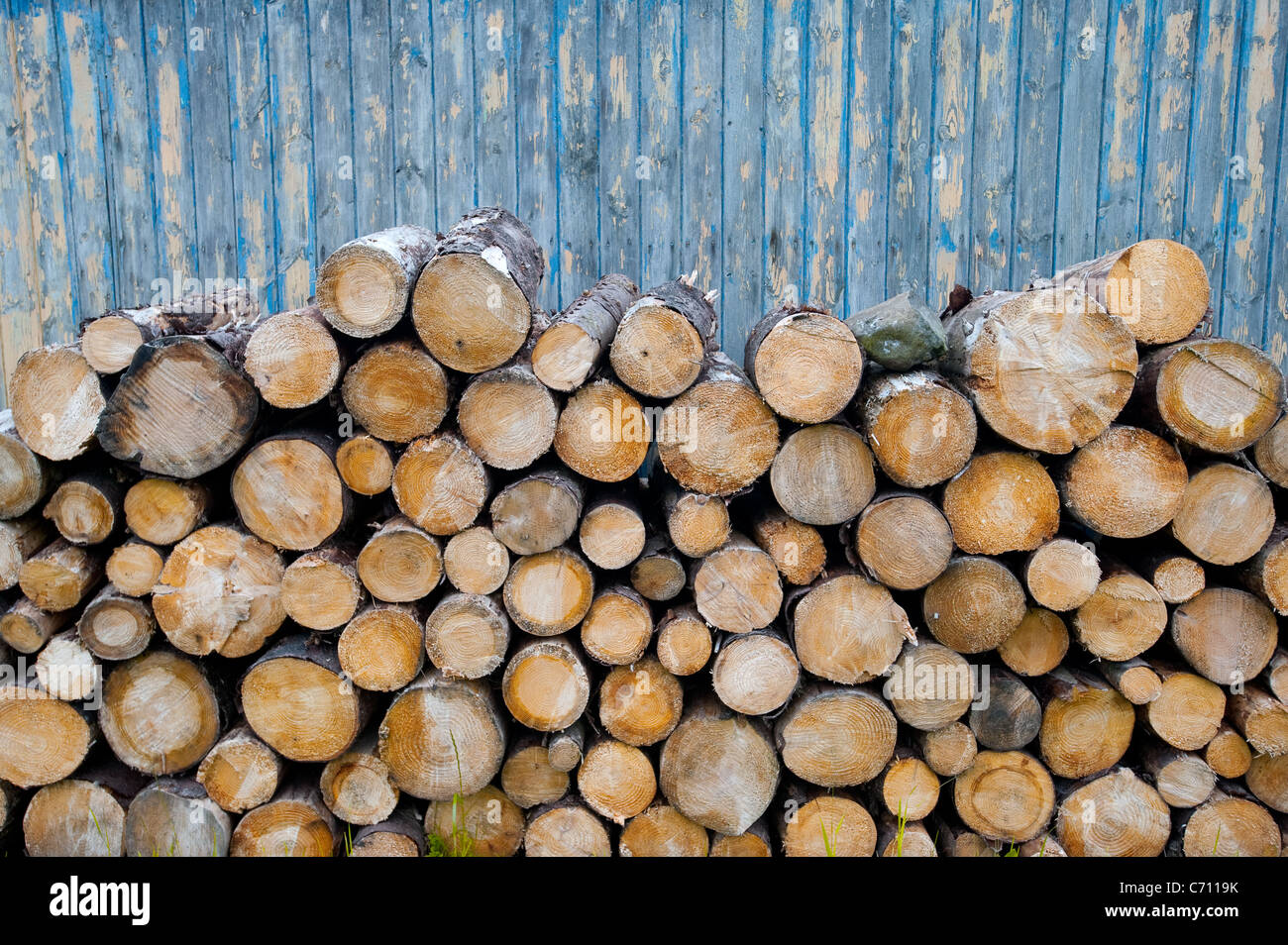 Stack of logs beside a cottage Stock Photo - Alamy