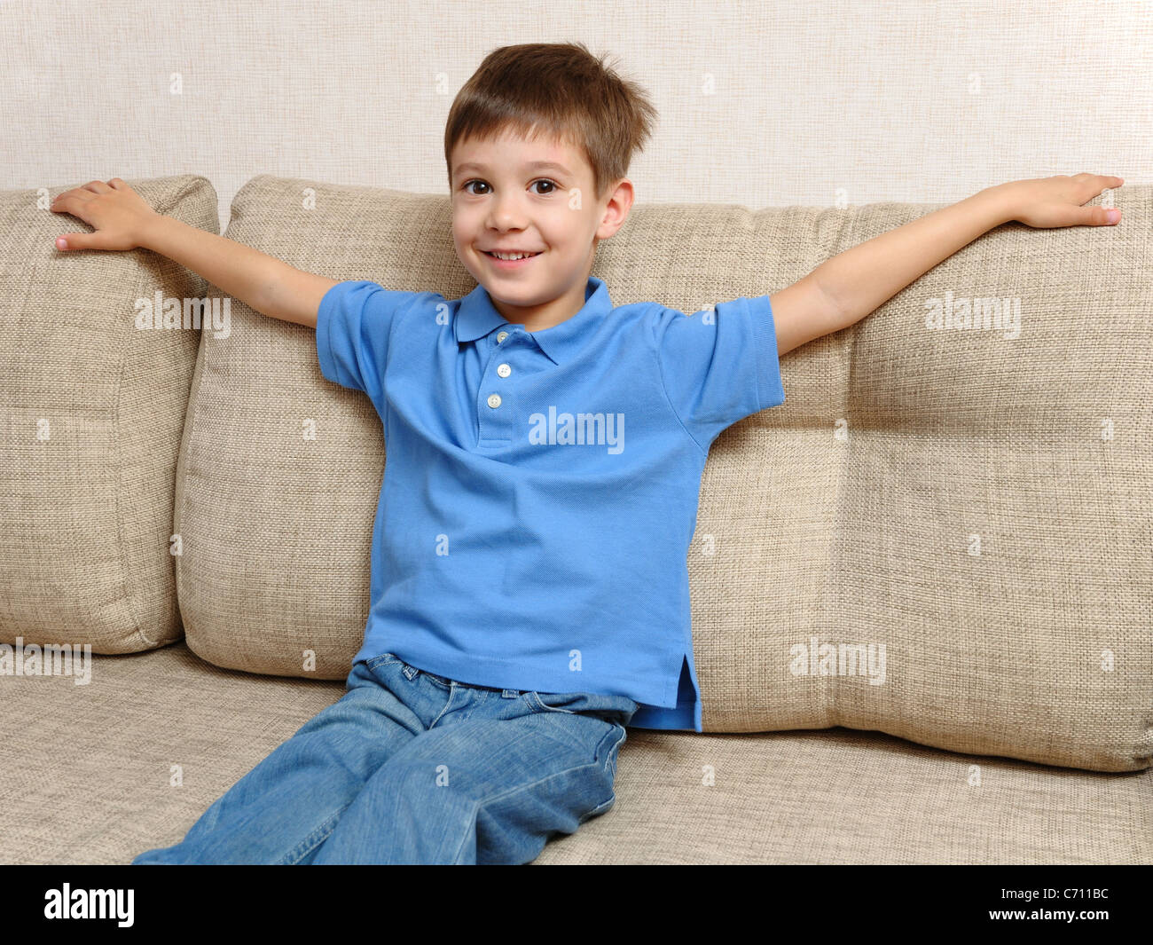 Happy child sitting on sofa Stock Photo - Alamy