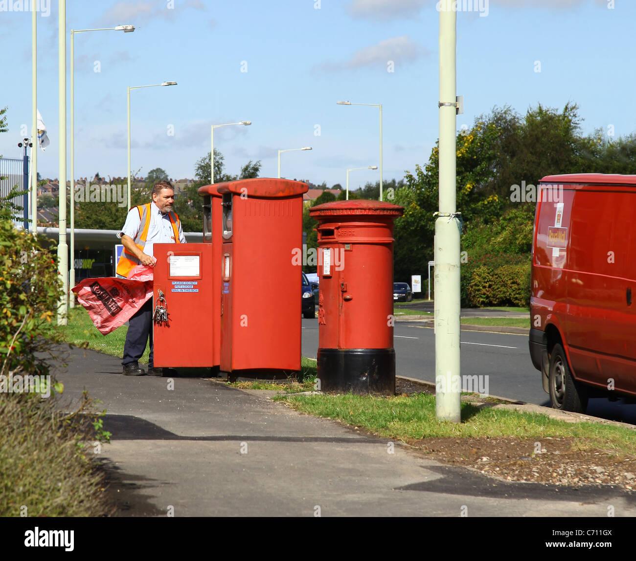 A postman collecting mail from a post box Stock Photo - Alamy