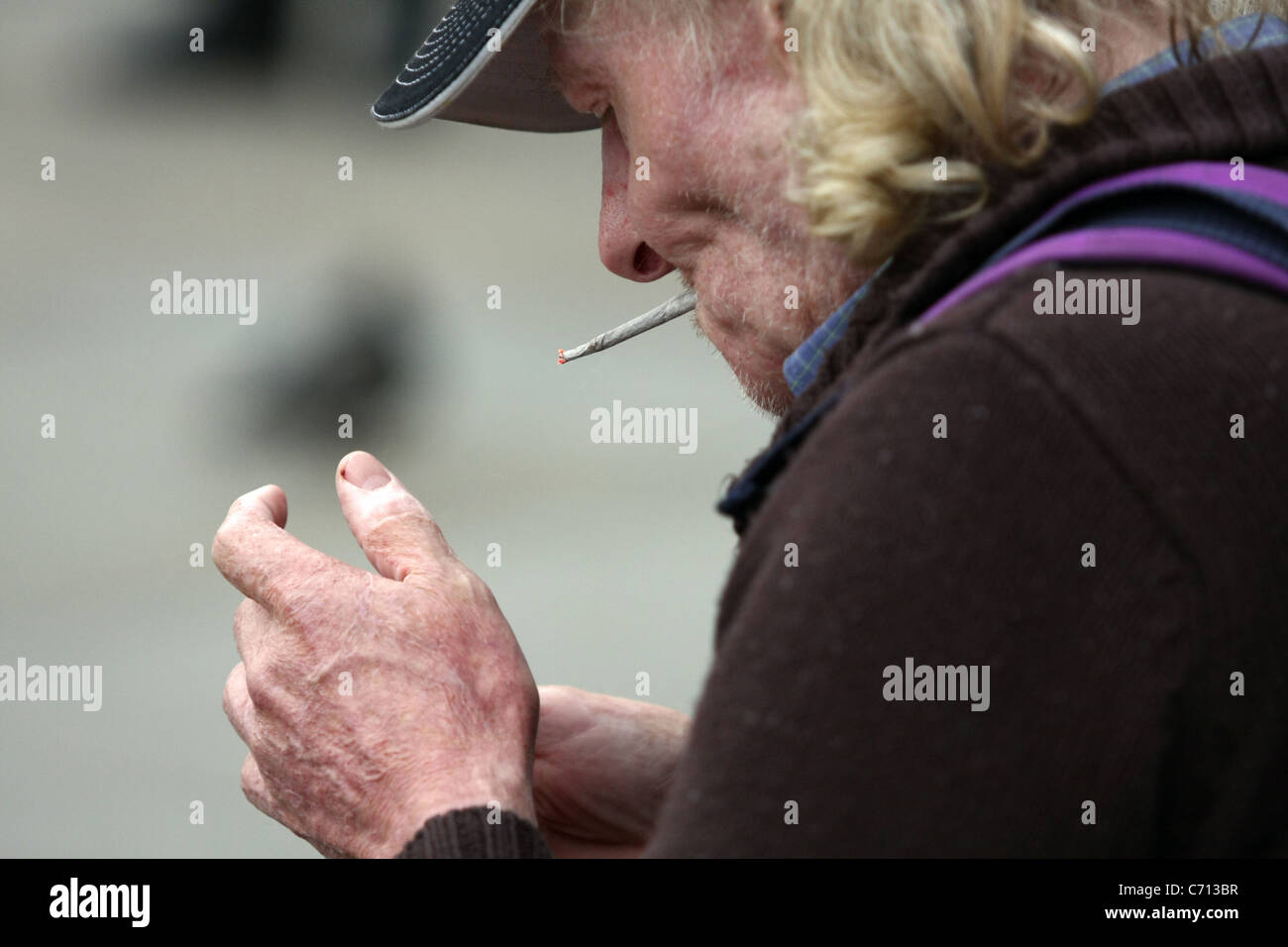 a mature man in the act of lighting a roll-up cigarette Stock Photo - Alamy