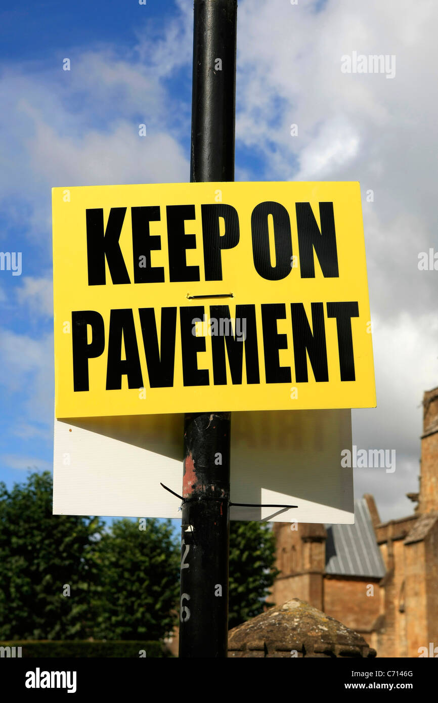 Black on Yellow Keep On Pavement sign Stock Photo - Alamy