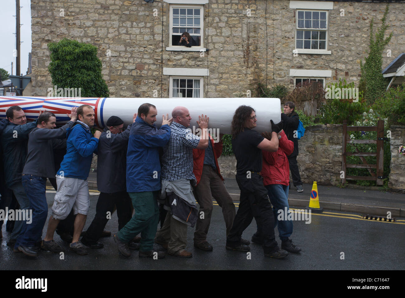 The newly decorated Maypole being put back into position at the center ...