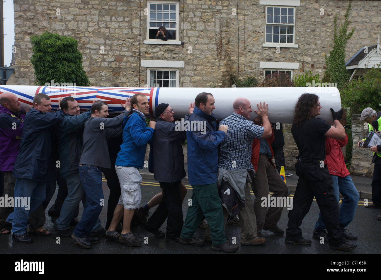 The newly decorated Maypole being put back into position at the center ...