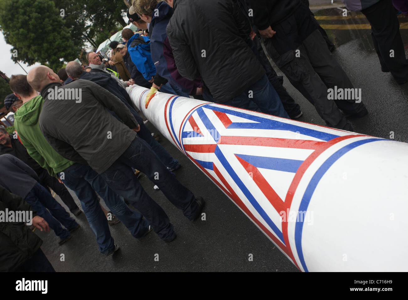 The newly decorated Maypole being put back into position at the center ...