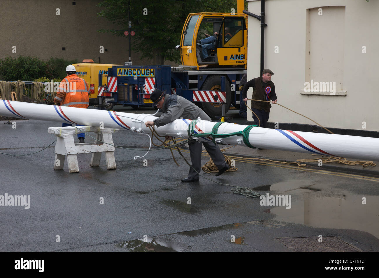 The newly decorated Maypole being put back into position at the center ...