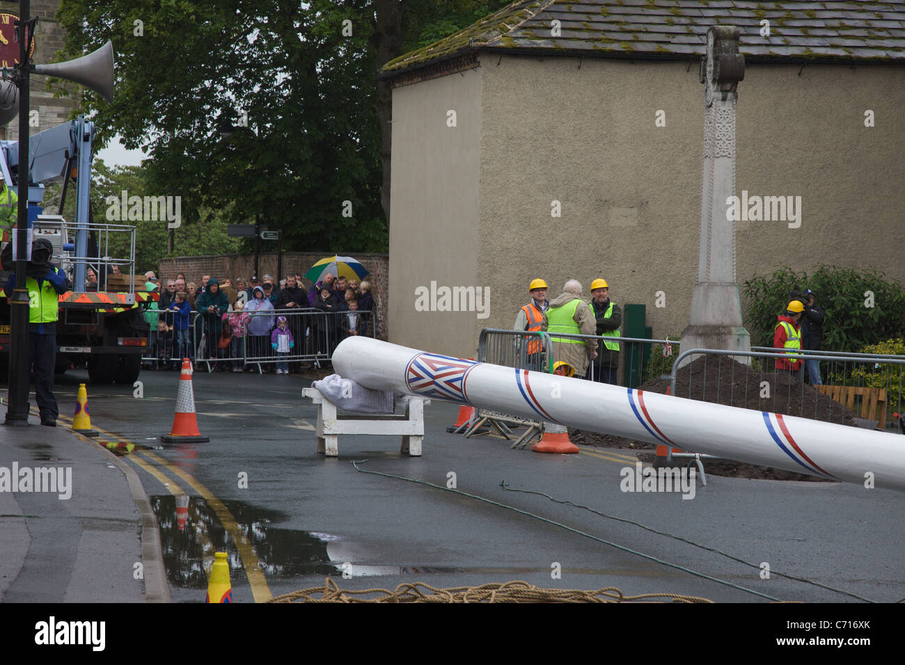 The newly decorated Maypole being put back into position at the center ...