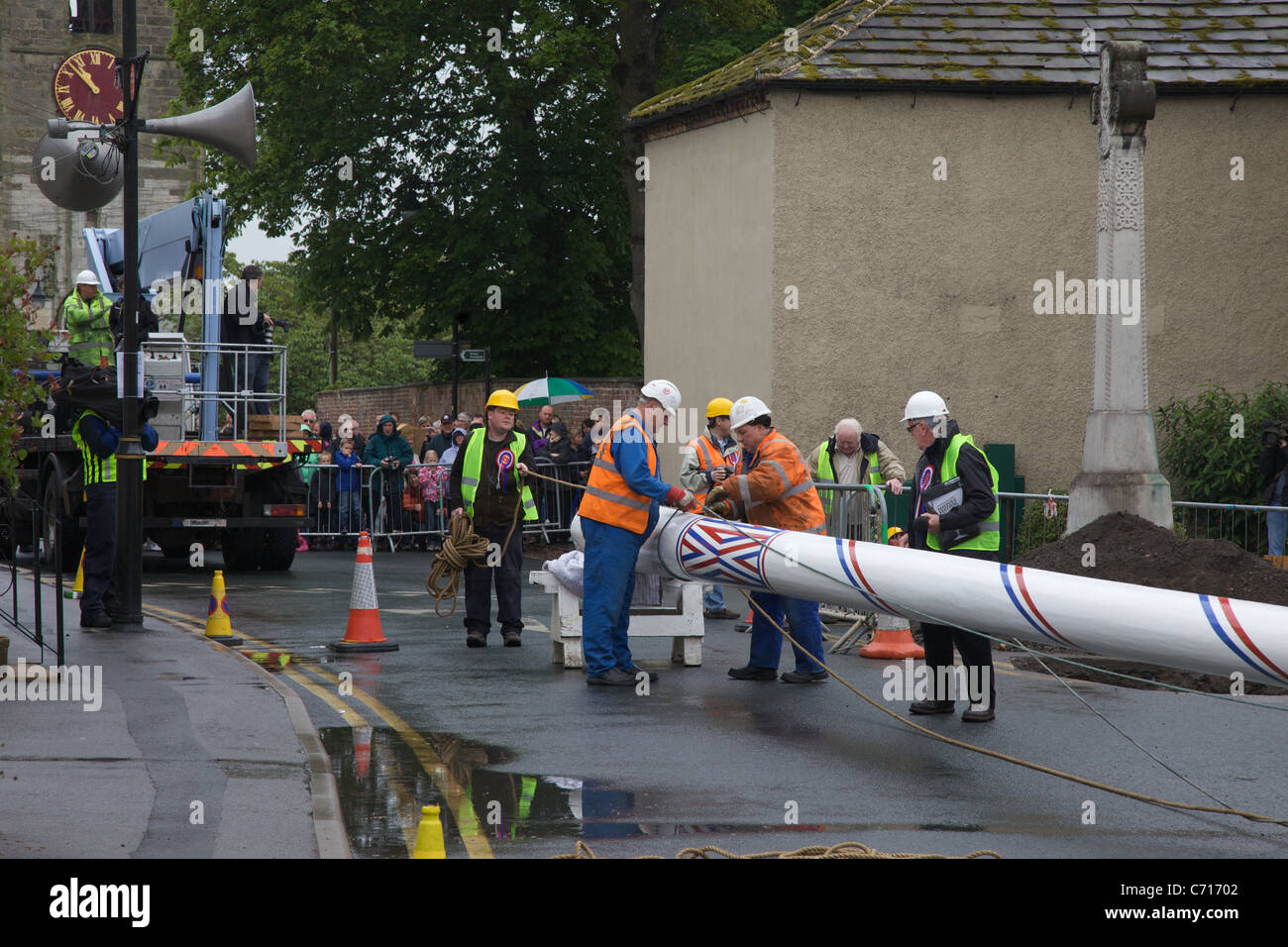 The newly decorated Maypole being put back into position at the center ...