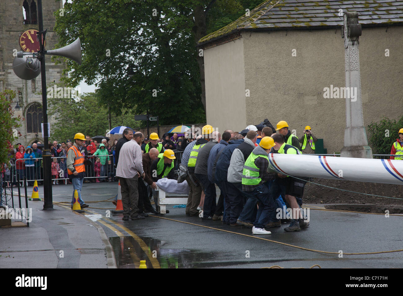 The newly decorated Maypole being put back into position at the center ...