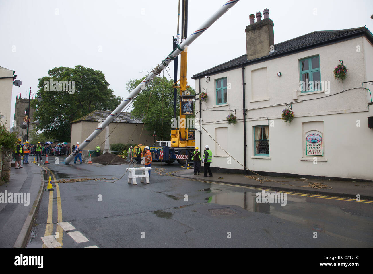 The newly decorated Maypole being put back into position at the center ...