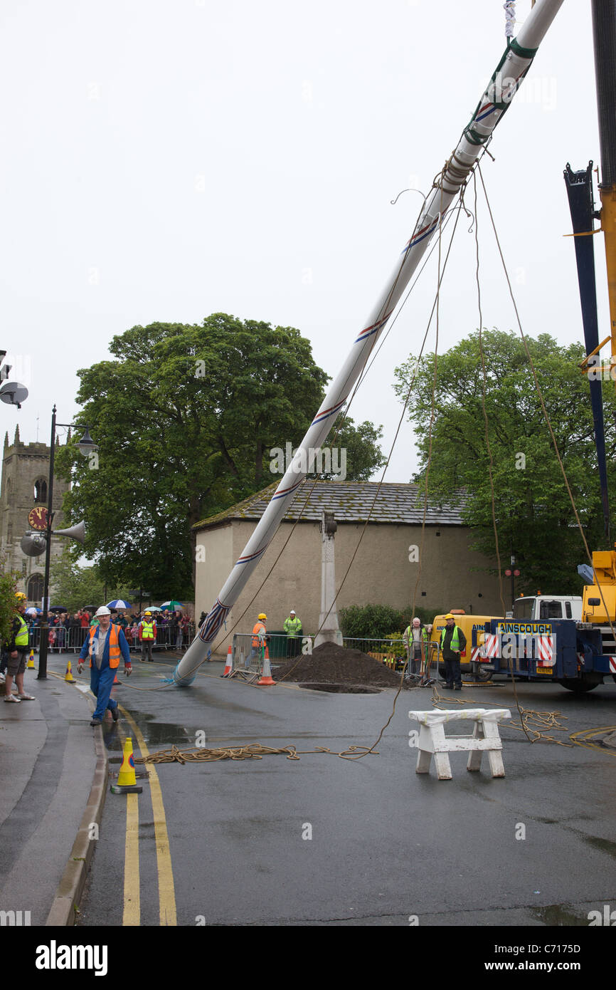 The newly decorated Maypole being put back into position at the center ...