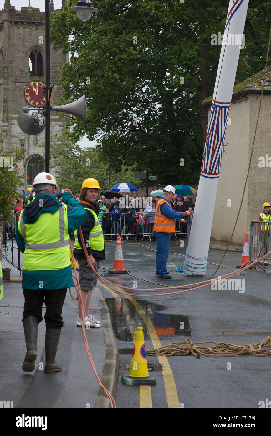 The newly decorated Maypole being put back into position at the center ...