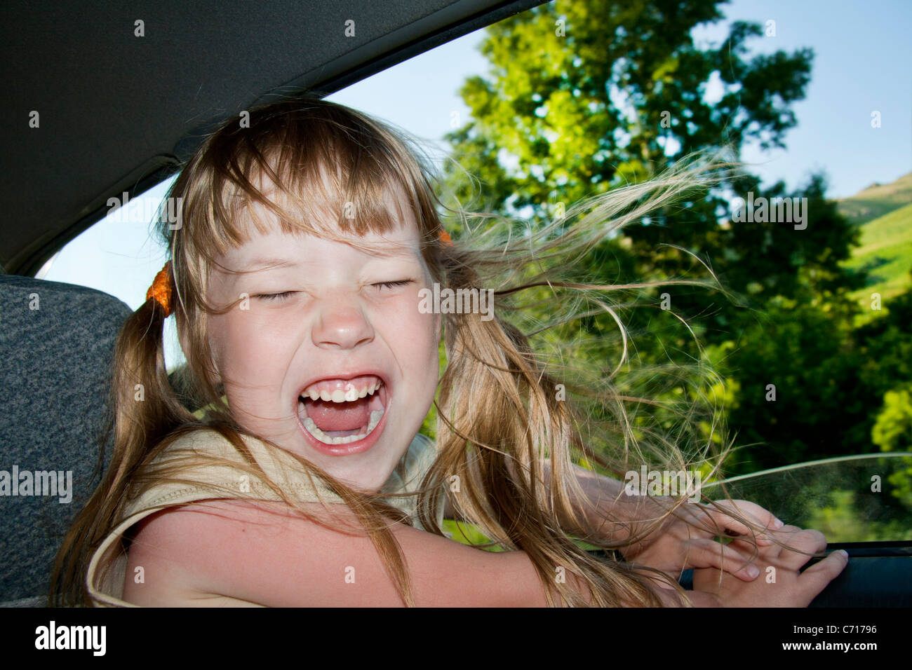 Little fun girl speeds in car near the open window Stock Photo - Alamy