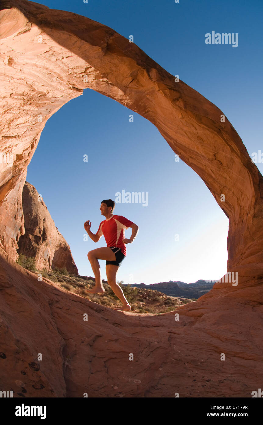 Barefoot male runner under sandstone arch, Moab, Utah Stock Photo - Alamy