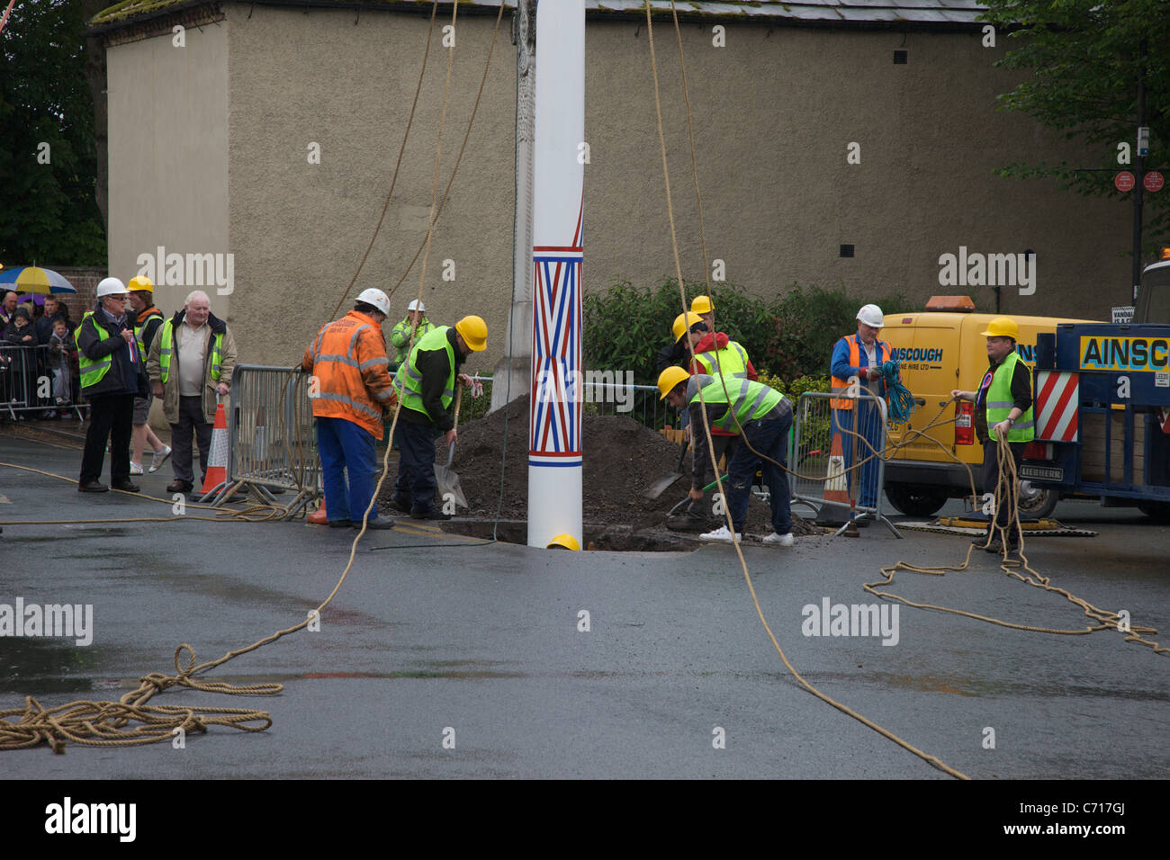 The newly decorated Maypole being put back into position at the center ...