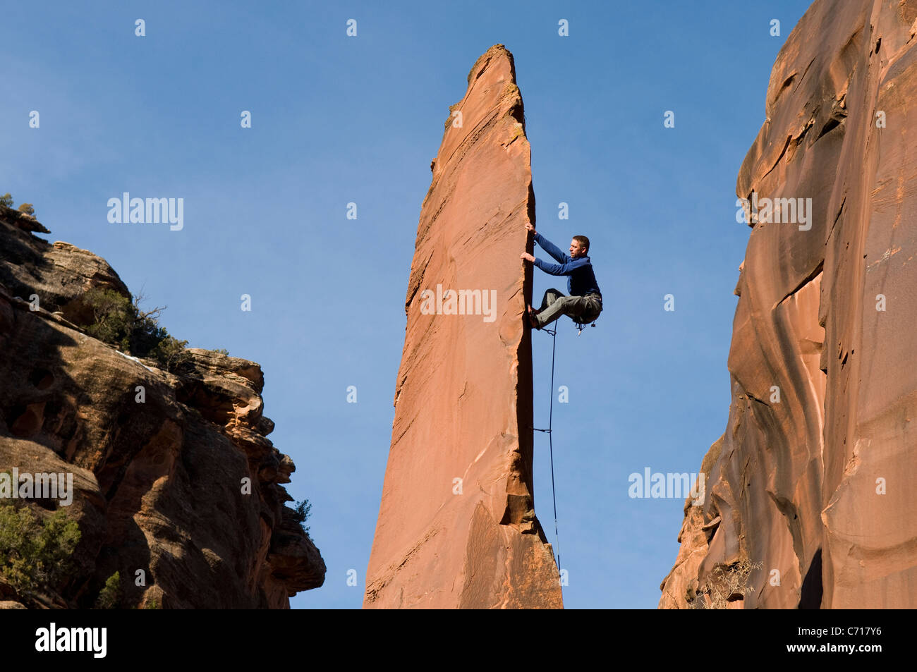Man rock climbing up slender sandstone spire, Gateway, Colorado Stock ...