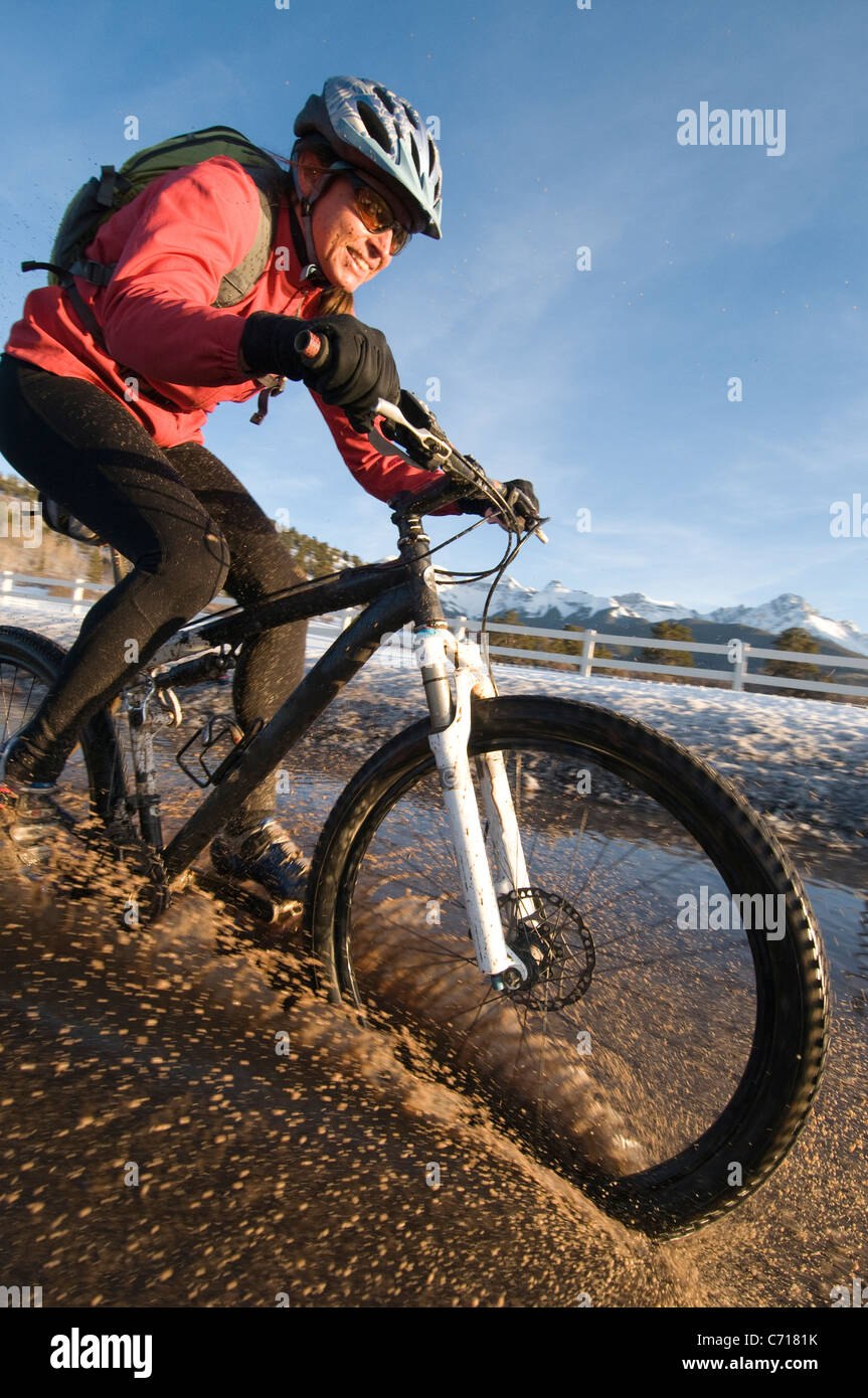 woman riding mountain bike through puddle, Ridgeway, Colorado Stock ...