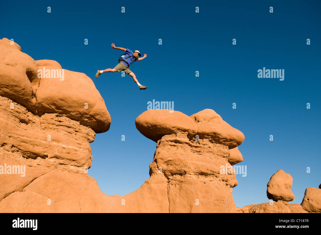Man jumping between rock spires, Goblin Valley State Park, Hanksville ...