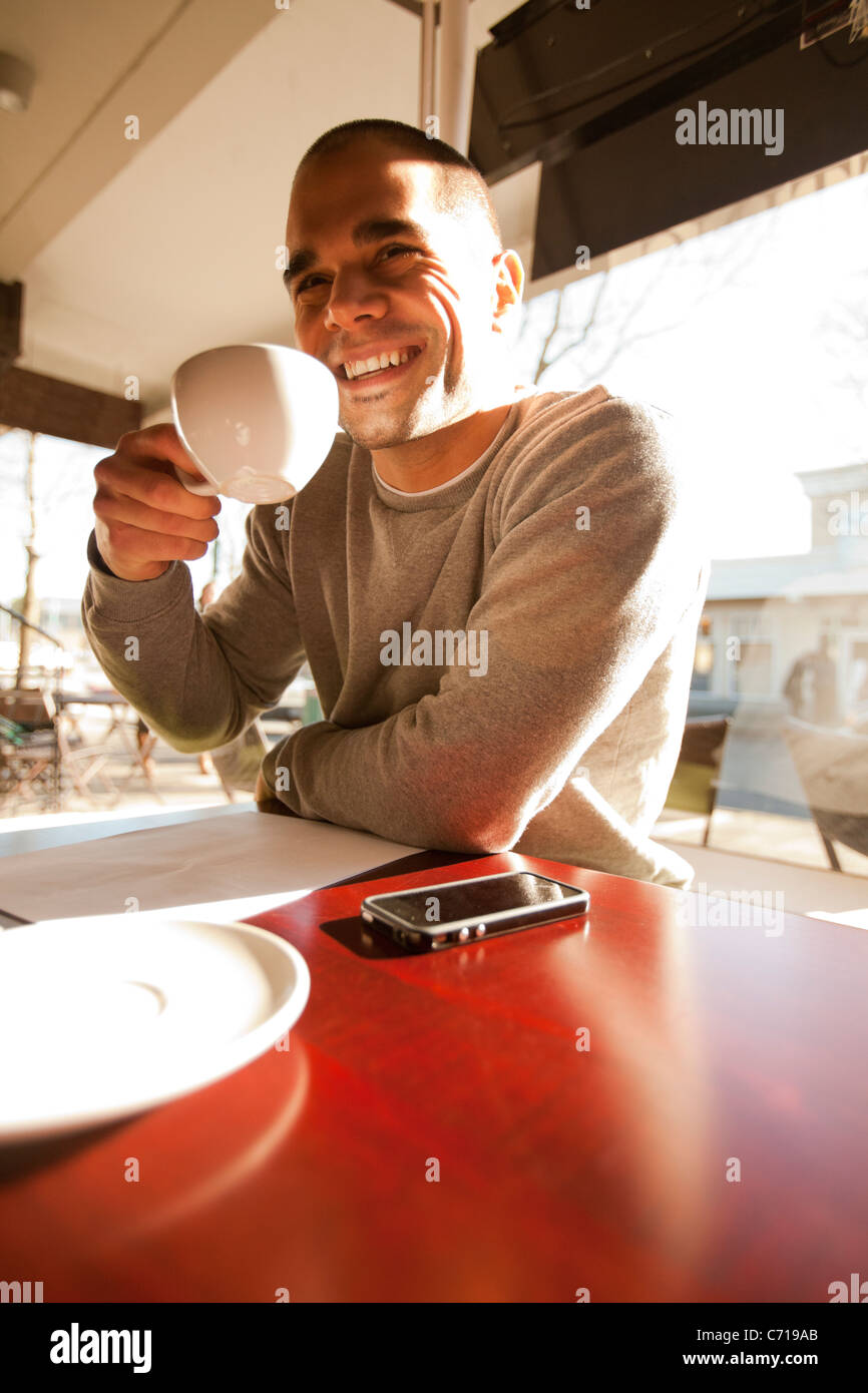A man enjoying a cup of coffee at a coffee shop Stock Photo - Alamy