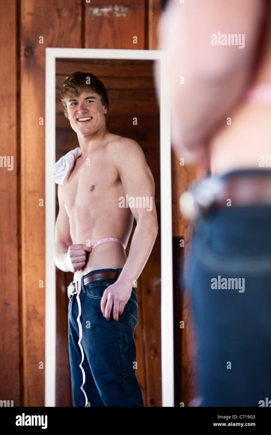 A young man measures his waist Stock Photo - Alamy
