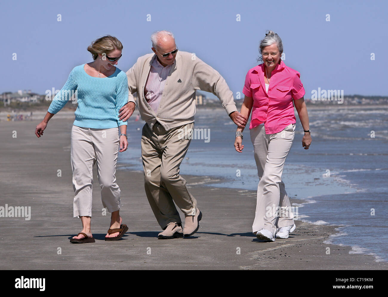 Friends walk down the beach to maintain an active healthy lifestyle ...