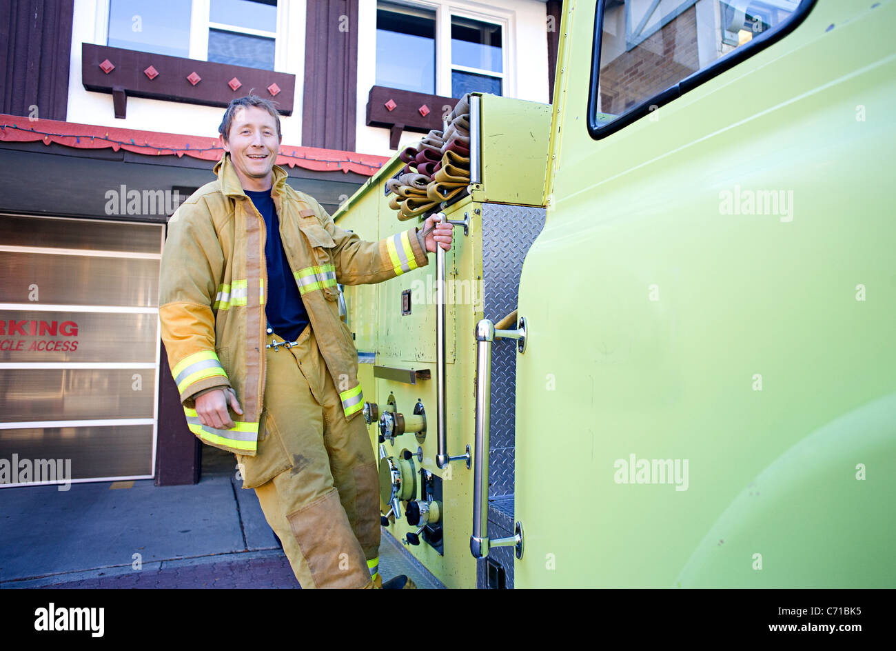 firefighter hangs on to side of fire truck Stock Photo - Alamy
