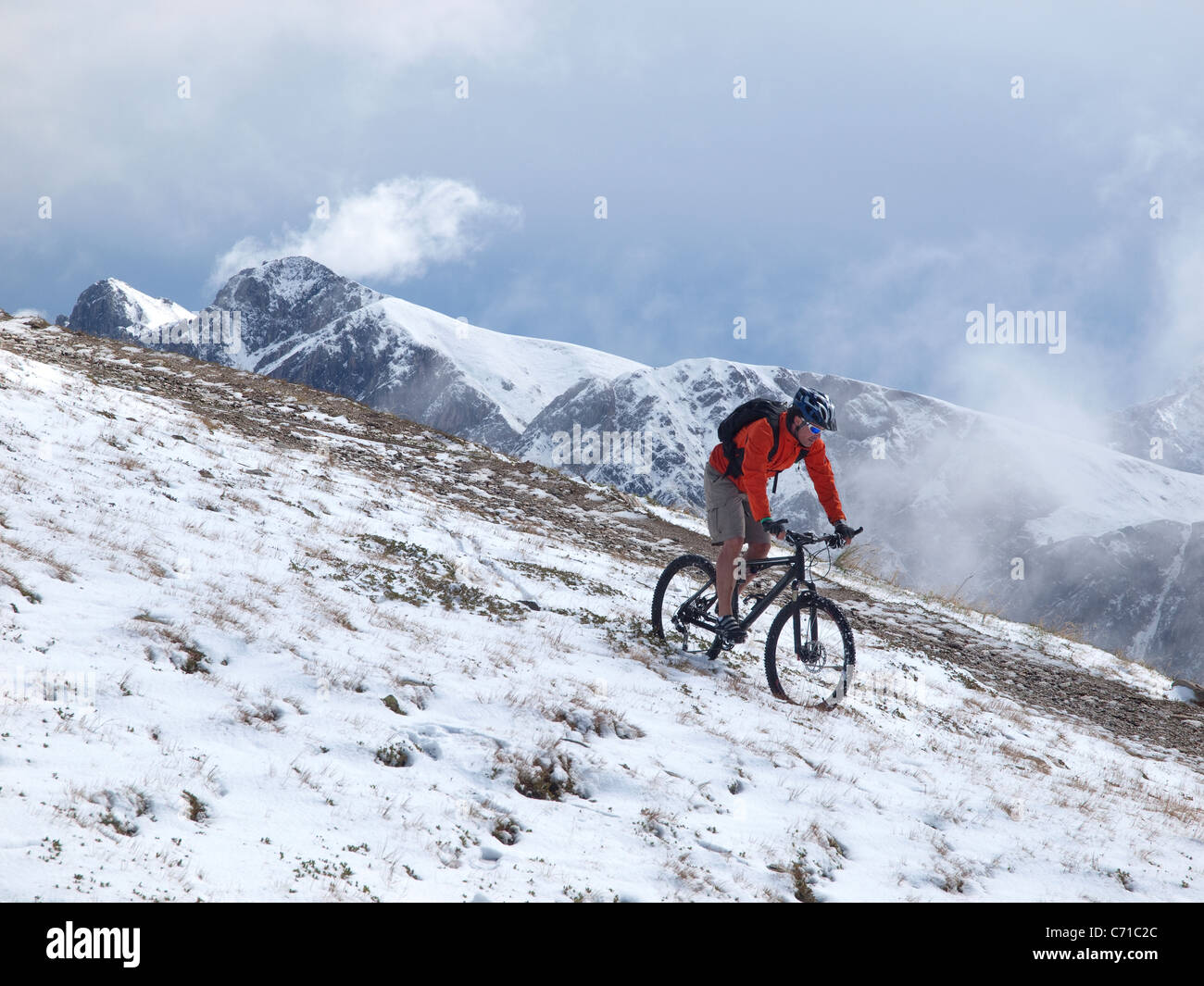 A mountain biker rides through the snow at Kronplatz, mountains and ...