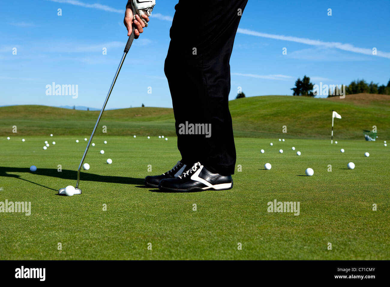Man lining up a putt while golfing Stock Photo - Alamy