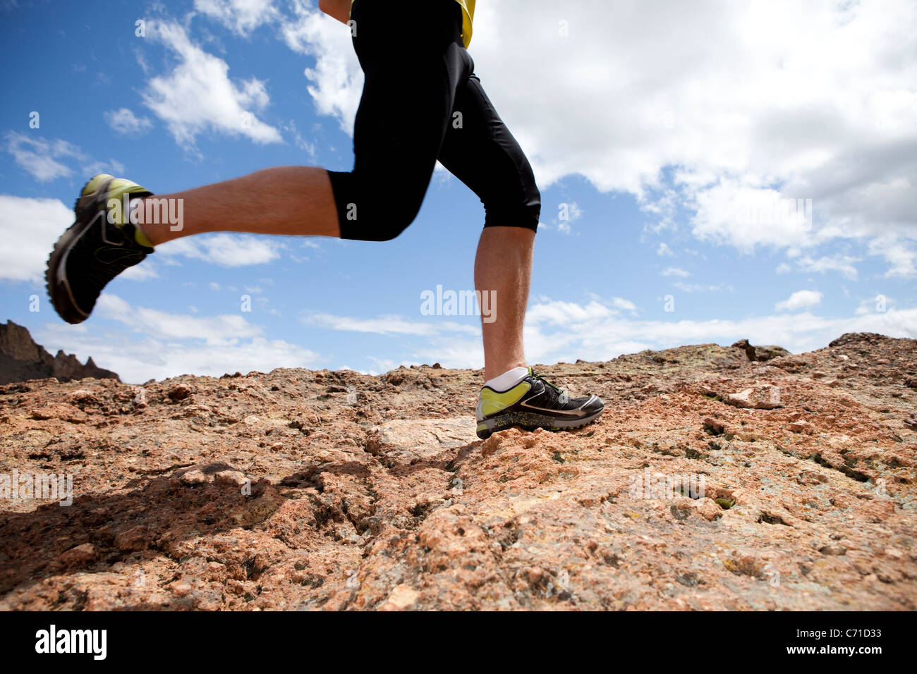 Male's legs trail running on rocks Stock Photo - Alamy
