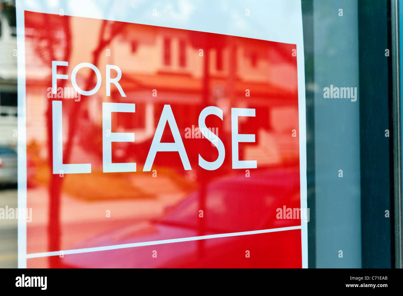 For Lease sign on red in window reflecting street scene Stock Photo - Alamy