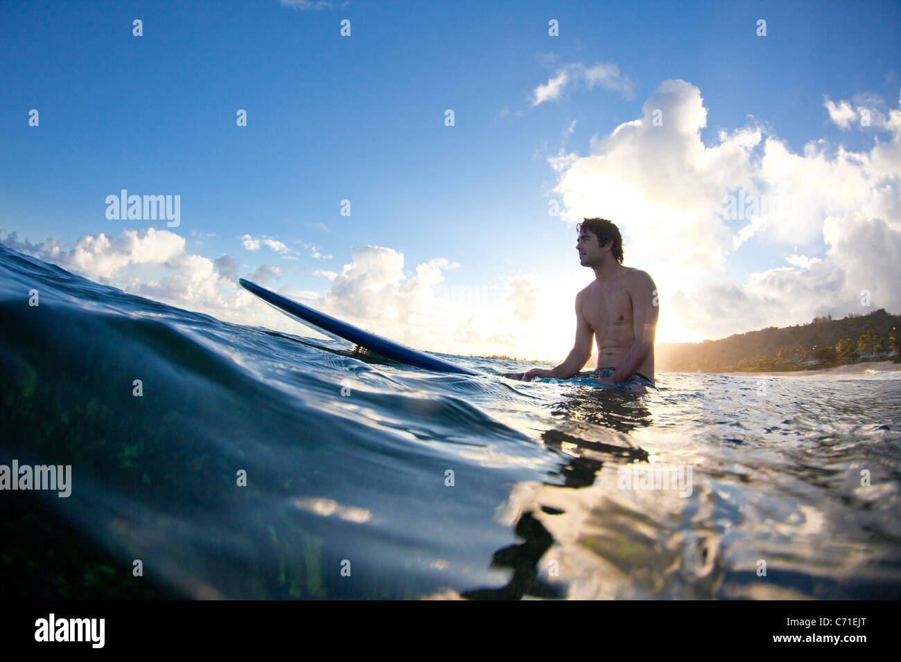 A young man surfing into the light at Monster Mush, on the north shore ...