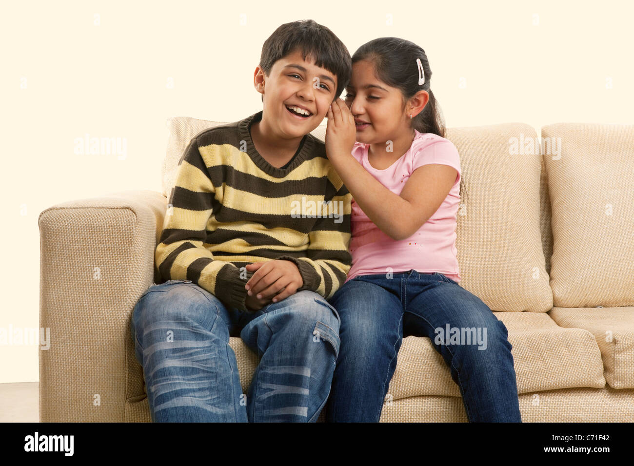 Girl whispering in her brothers ear Stock Photo - Alamy