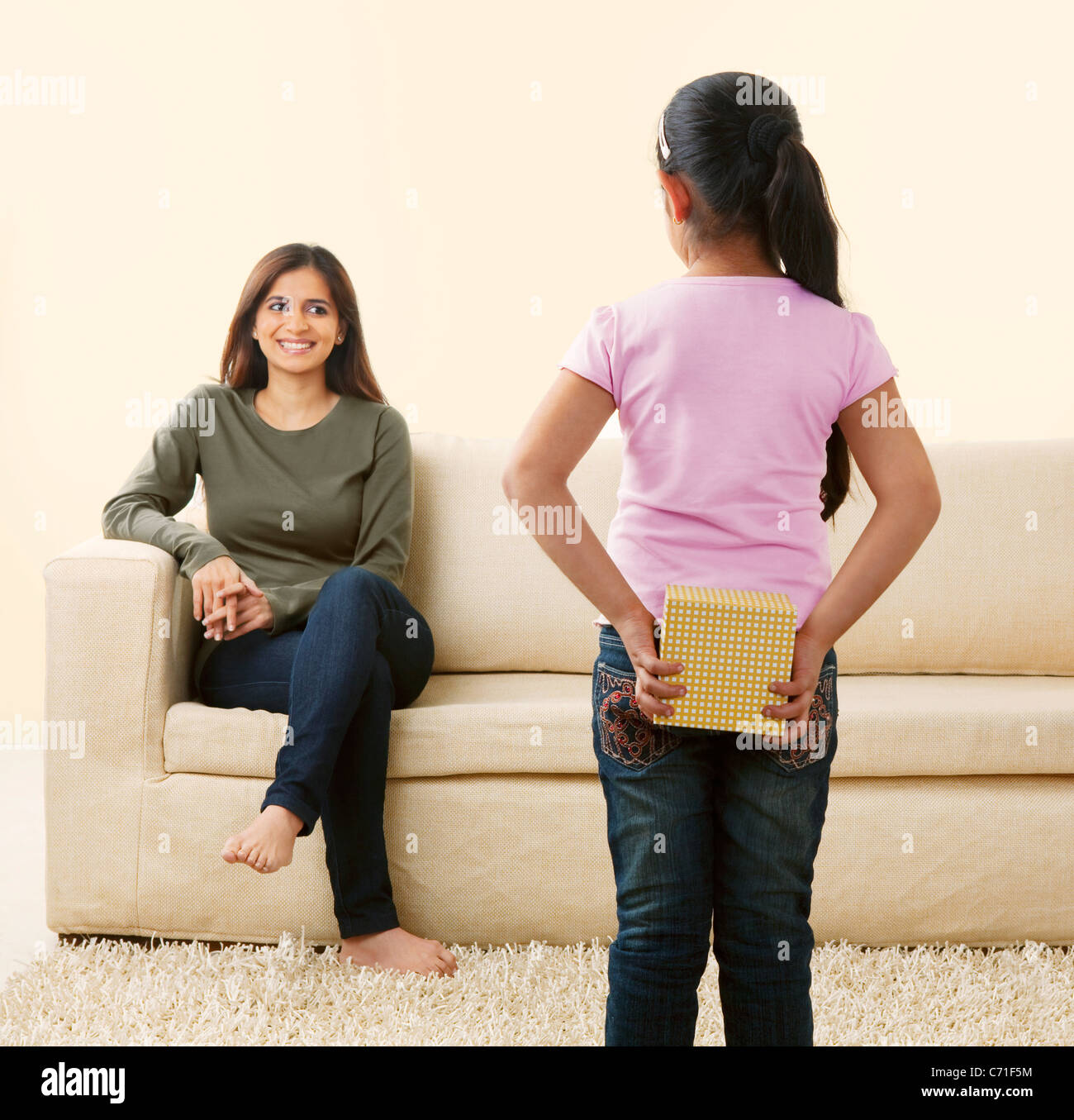 Girl hiding a gift from her mother Stock Photo - Alamy