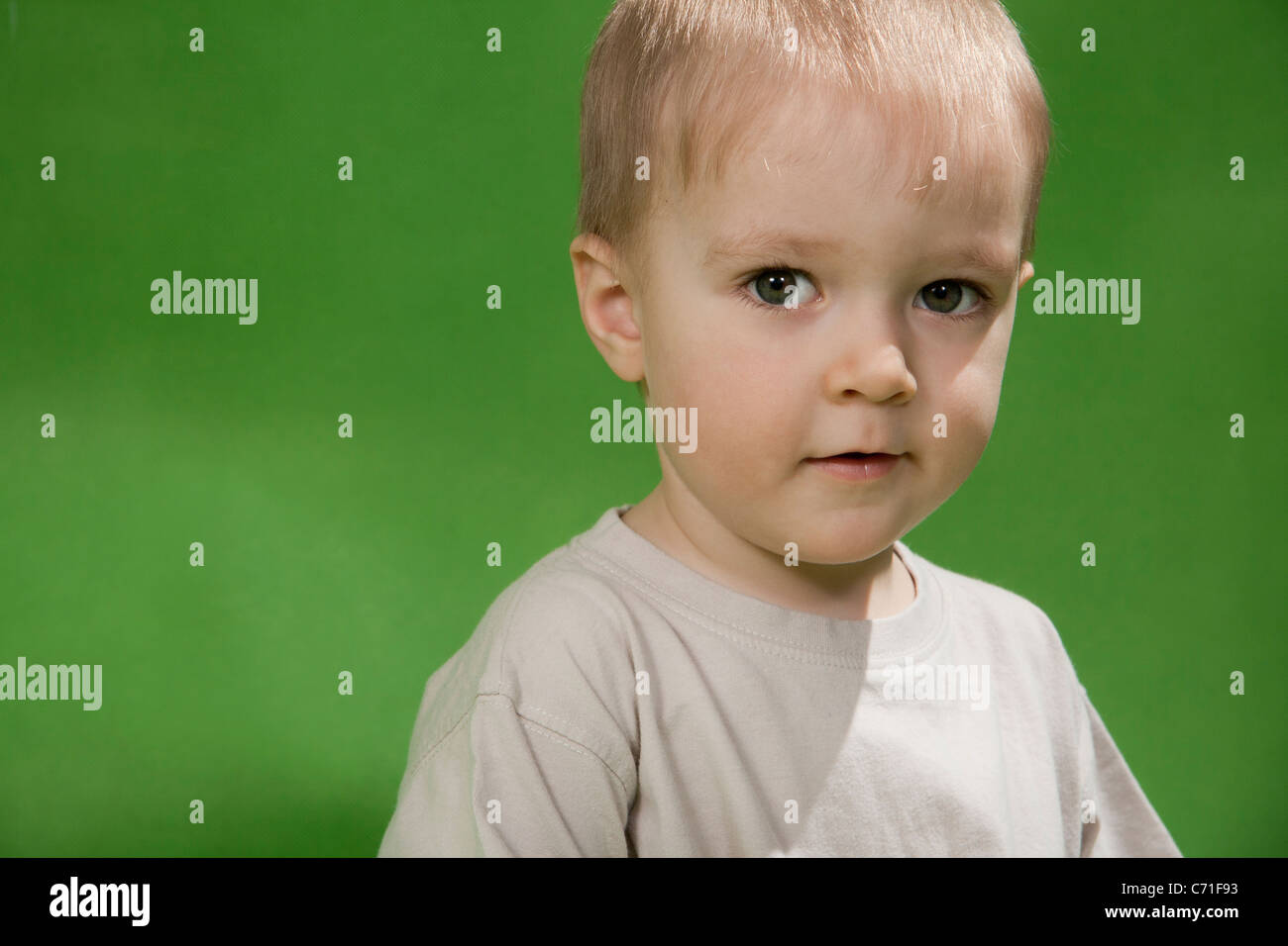 lovely little boy on a green background Stock Photo - Alamy
