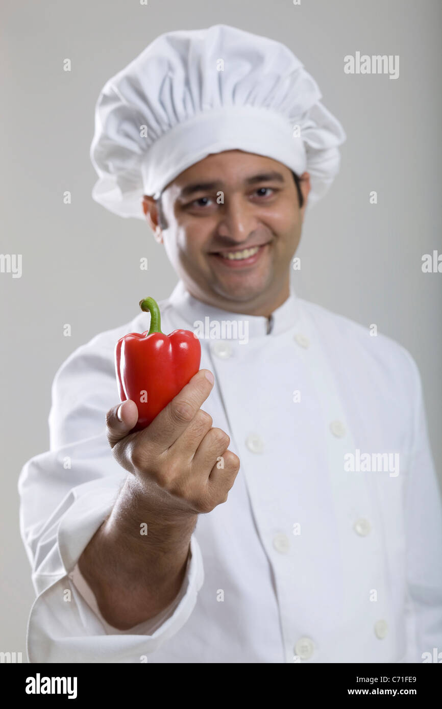 Portrait of a chef holding a red bell pepper Stock Photo - Alamy