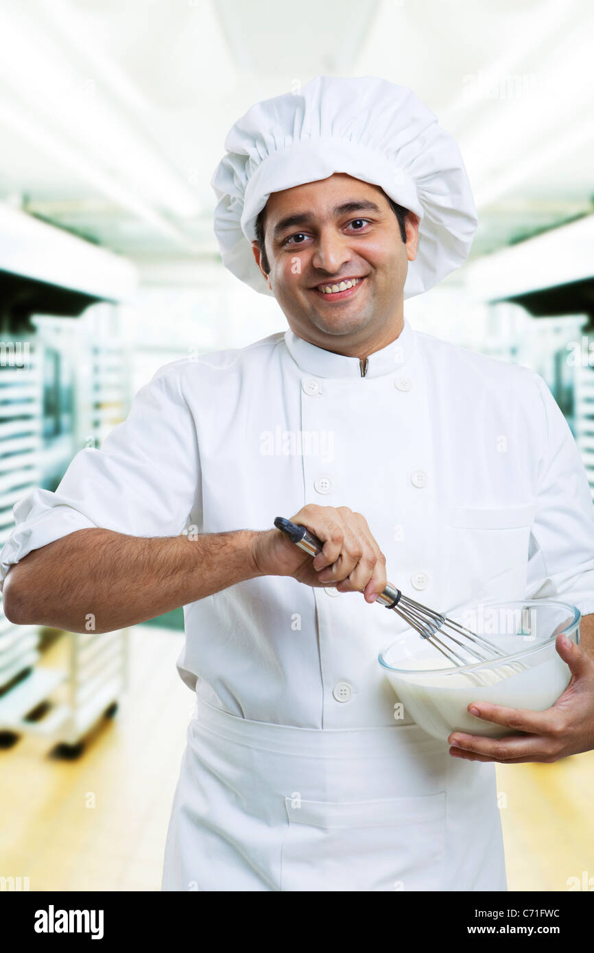 Chef beating dough in a bowl Stock Photo - Alamy