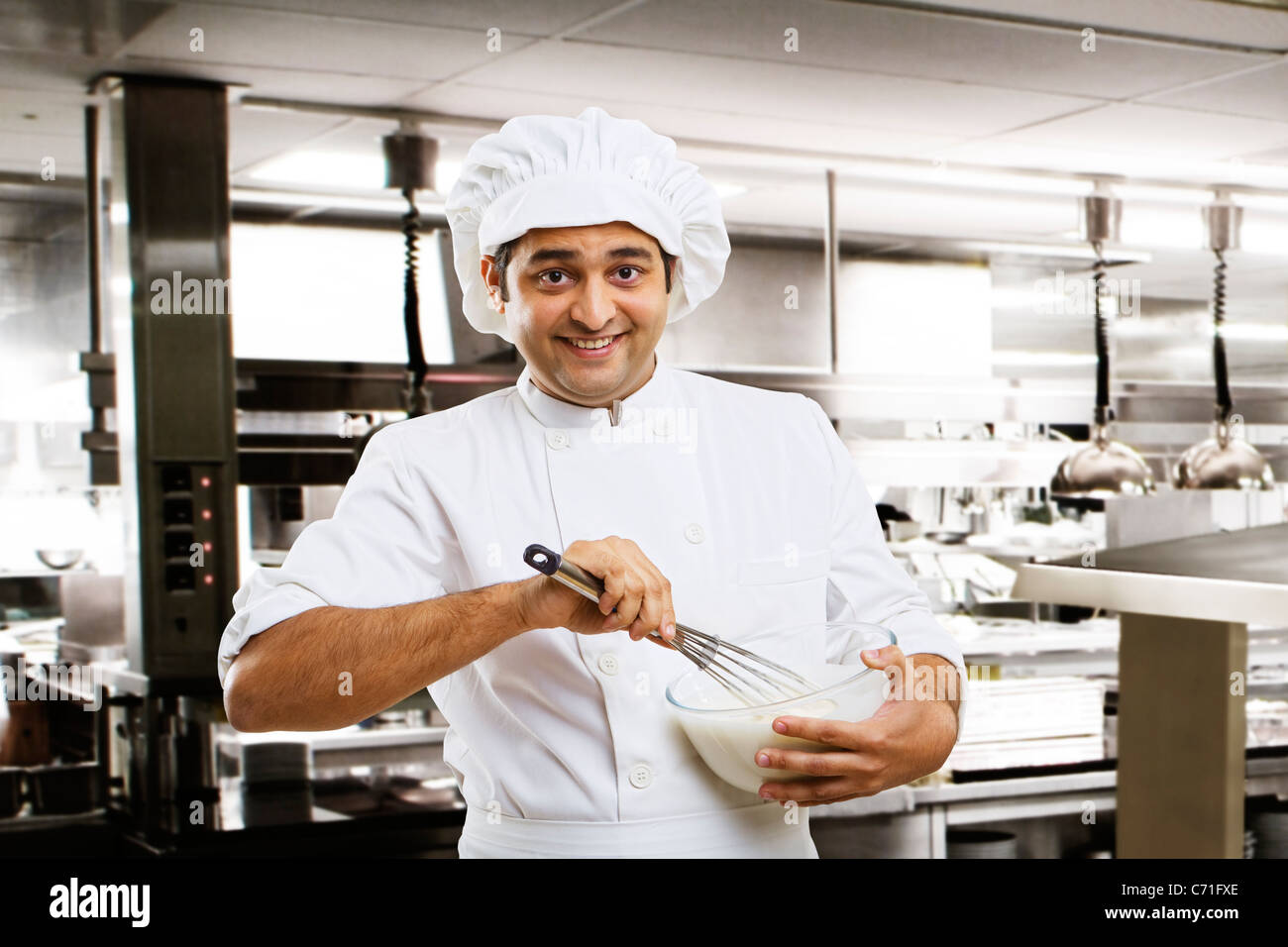 Chef beating dough in a bowl Stock Photo - Alamy