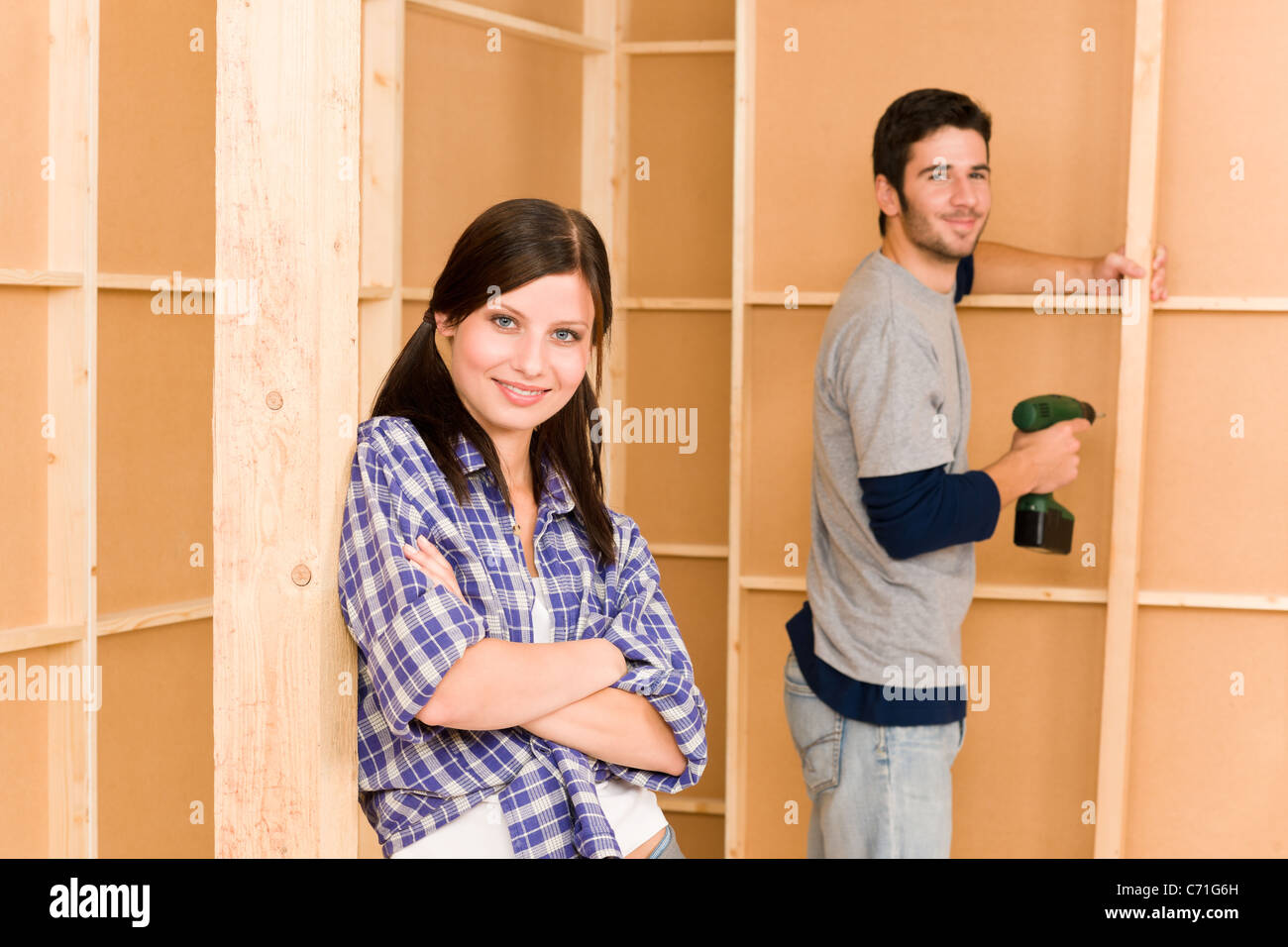 Home improvement smiling young couple fixing wall with hand drill Stock ...