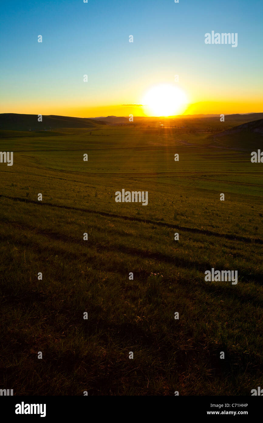 Sun rising over a field Stock Photo - Alamy