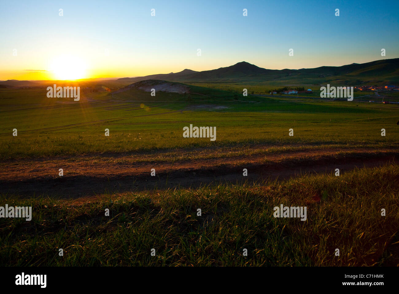 Sun rising over a field Stock Photo - Alamy